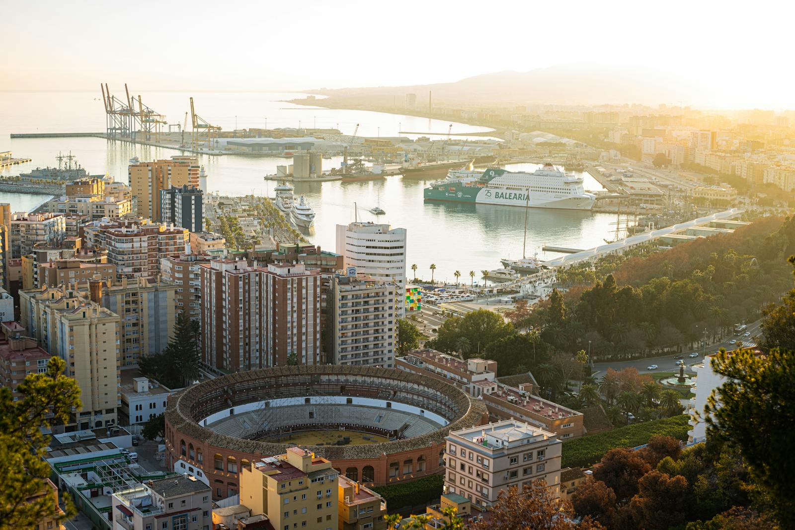 Aerial shot of Malaga bullring and harbor at sunset