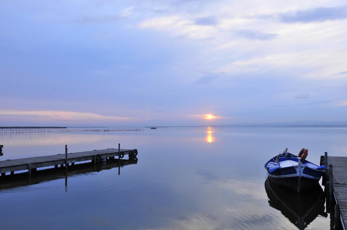 Golden sunset over the Albufera lagoon near Valencia with a wooden jetty extending into the water