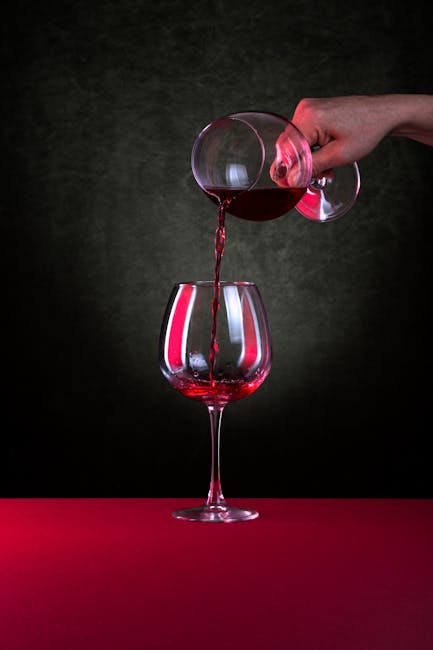 Red wine being poured into a glass during a winery tasting