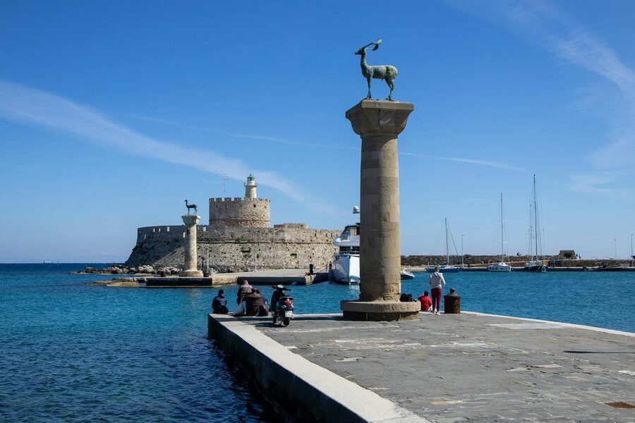 Mandraki Harbor with medieval fort and deer statues in Rhodes