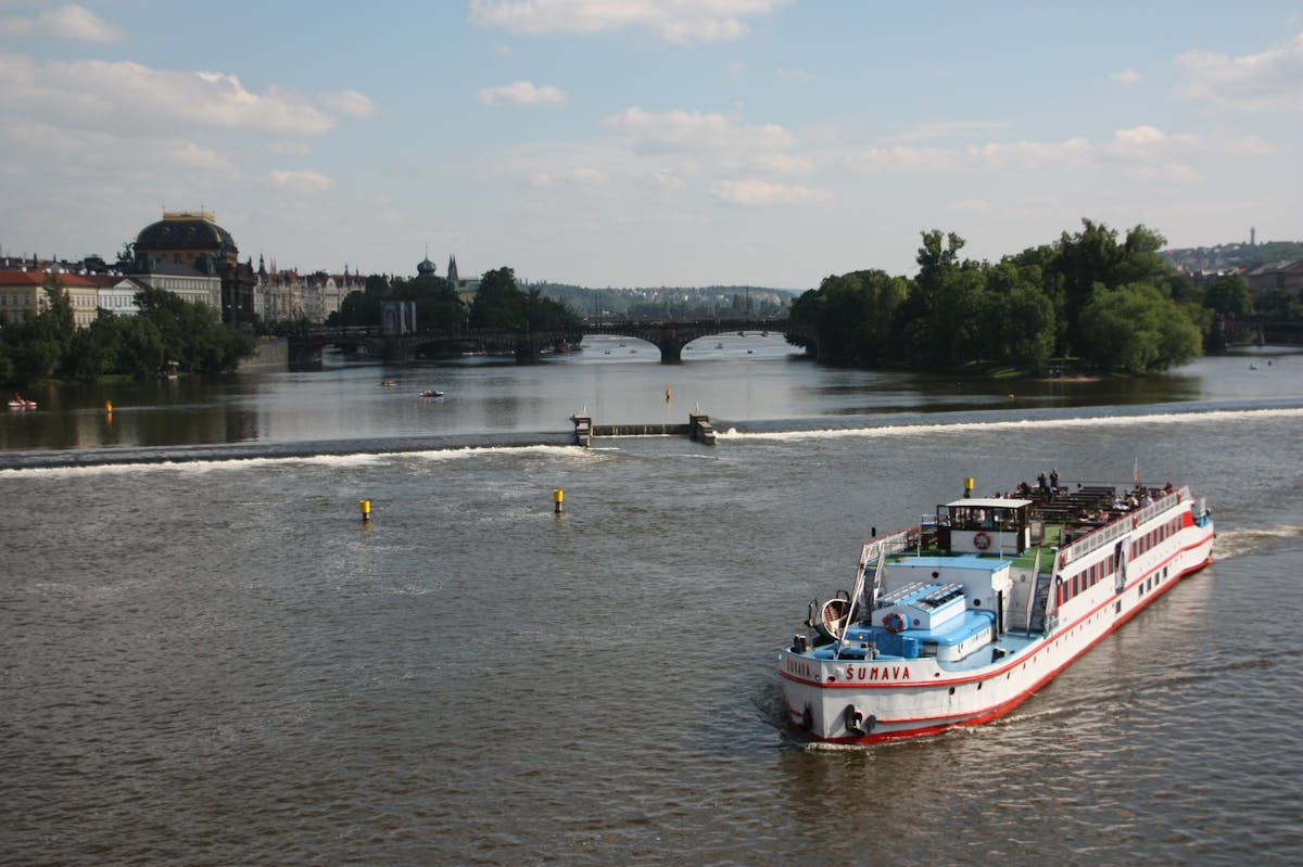 A sightseeing boat on the Vltava River passing historic Prague buildings