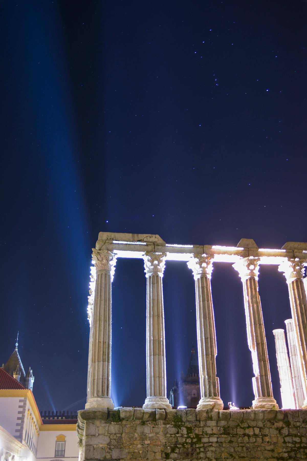 The Roman Temple of Évora illuminated against a dark sky