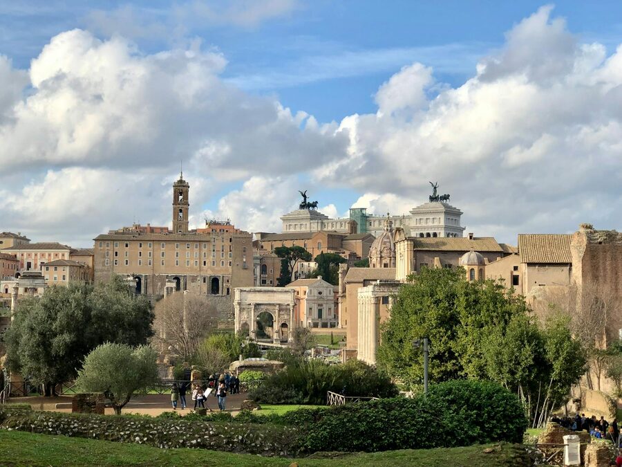 Aerial view of Rome showcasing architecture and lush greenery under blue sky