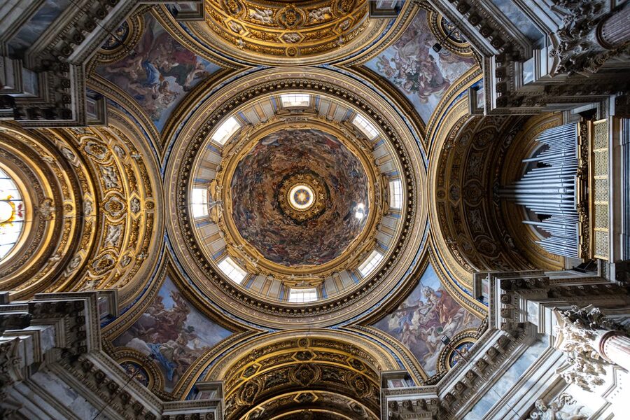Stunning interior of a Roman baroque church with ornate dome ceiling