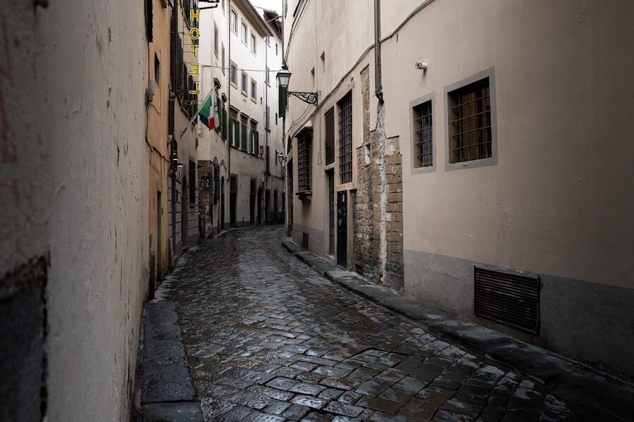 A quiet cobblestone alley in Rome with classic Italian architecture