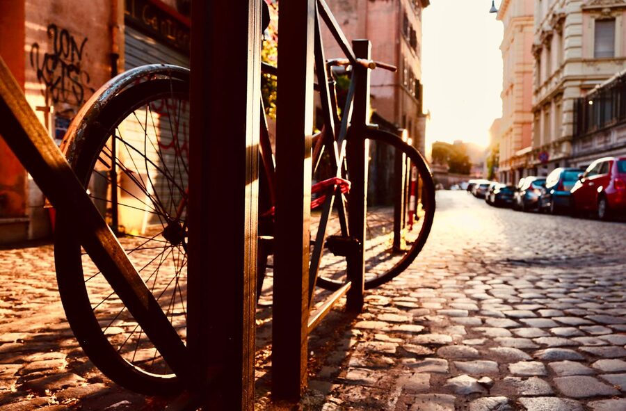 Bicycle parked on a cobblestone street in Rome during a warm sunset
