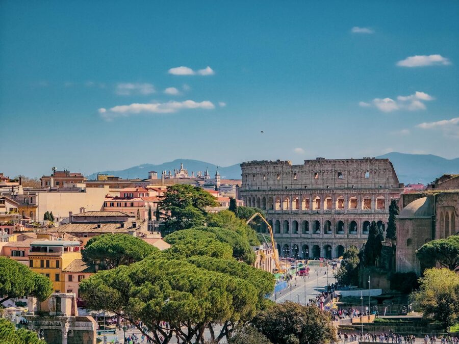 A view of Rome featuring the Colosseum on a sunny day with clear blue sky