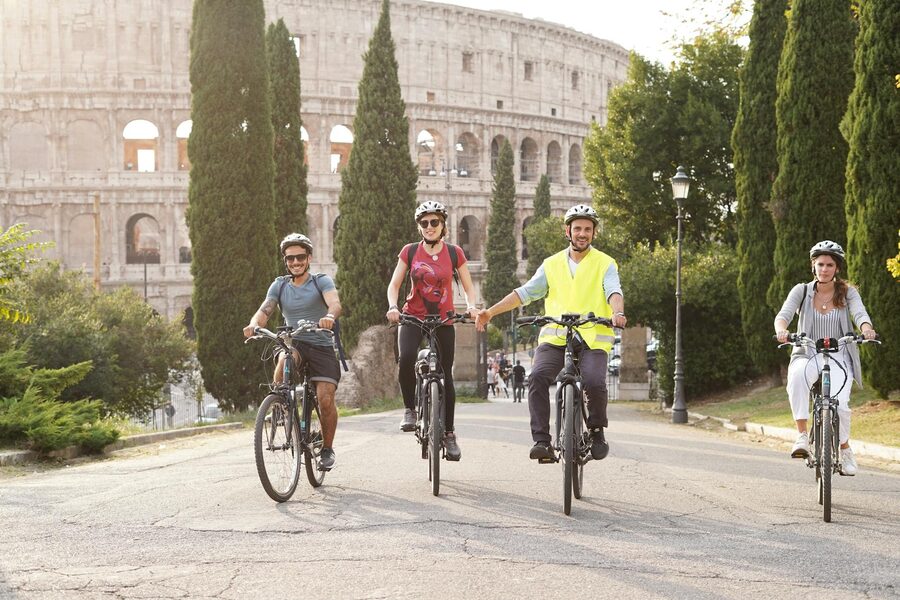 Group of cyclists enjoying a summer bike tour near the Colosseum in Rome