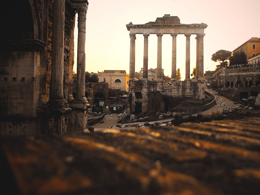 The Roman Forum ruins bathed in golden sunset light in Rome Italy