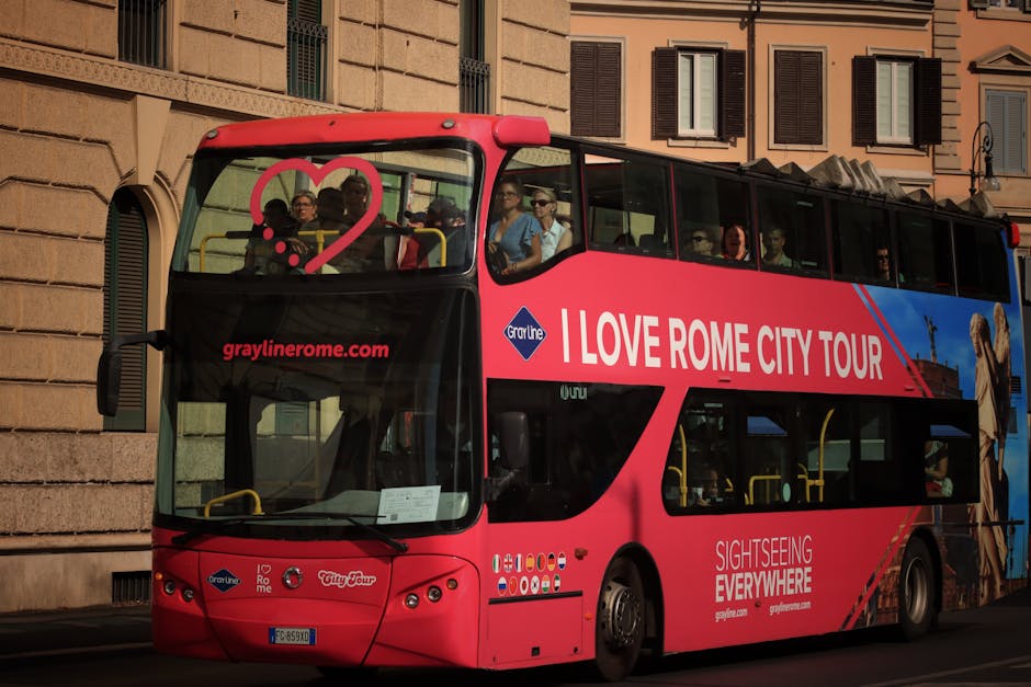 Double-decker open-top sightseeing bus driving through Rome with tourists on the upper deck