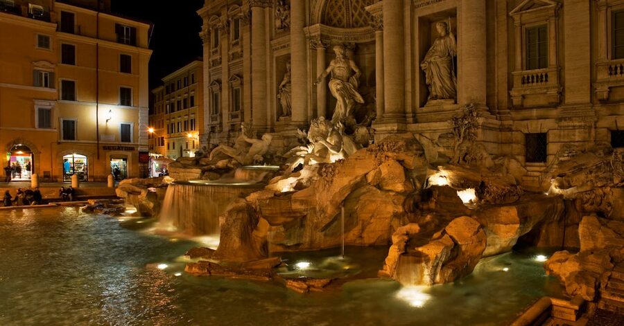 Wide view of the Trevi Fountain beautifully illuminated at night in Rome