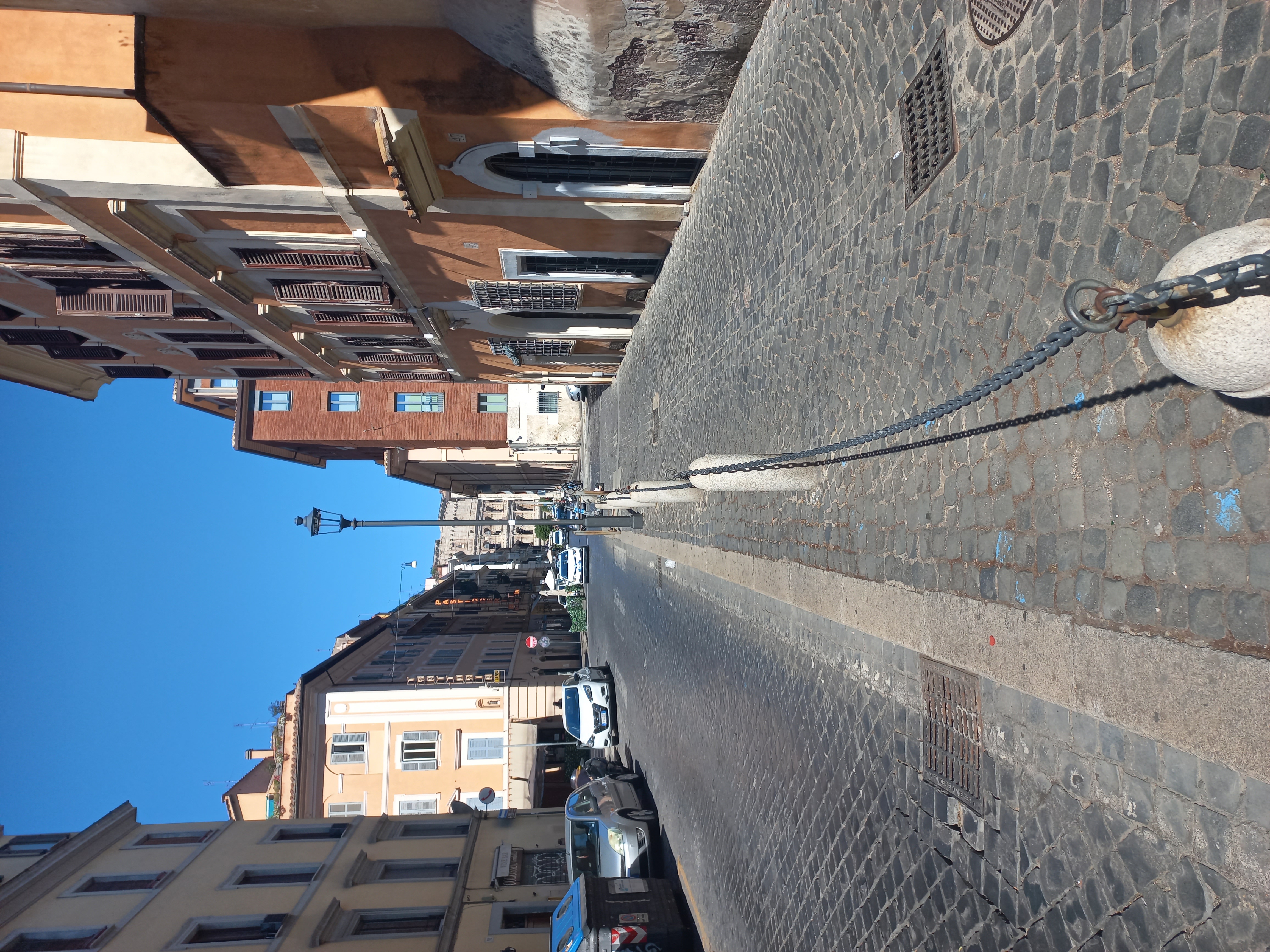 A narrow street in Rome with historic buildings
