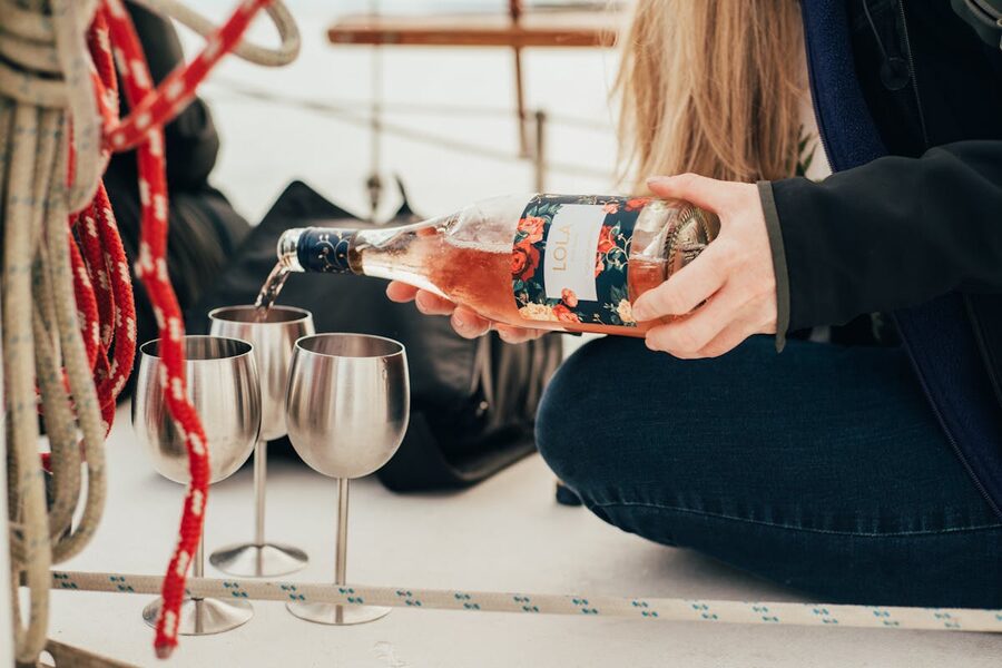 Rose wine being poured into glasses while sailing on a boat