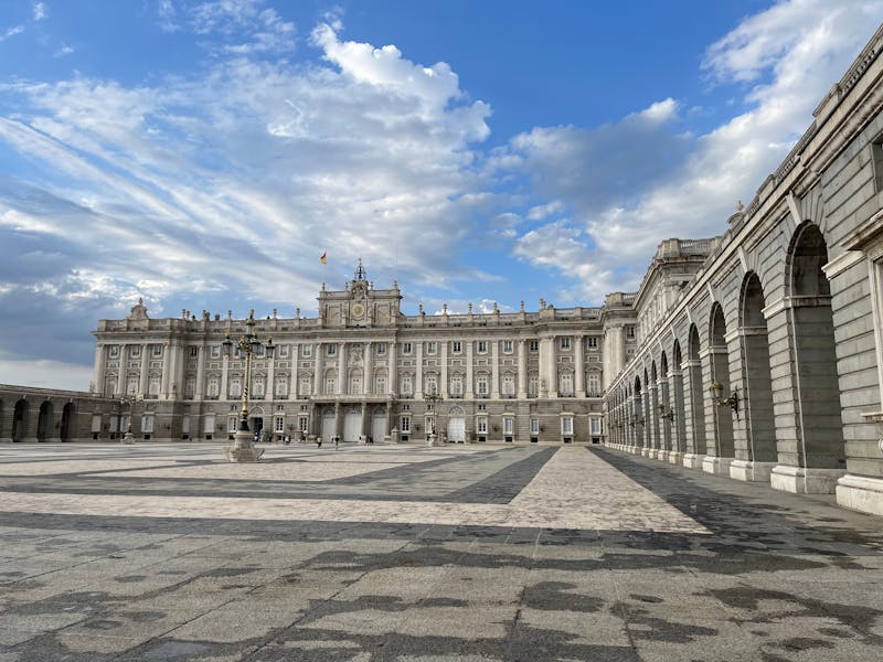 A wide view of the Royal Palace of Madrid against a vivid blue sky