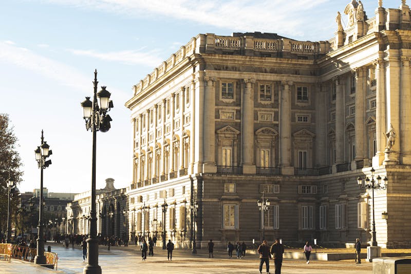 The Royal Palace of Madrid facade bathed in golden afternoon sunlight