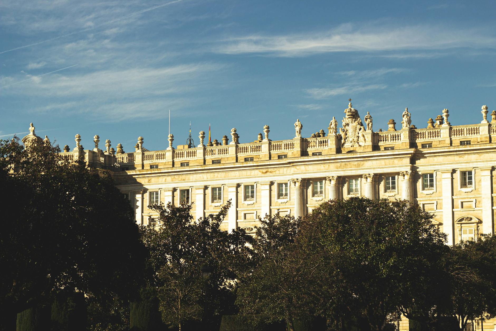 Sunlit view of the Royal Palace in Madrid showing its classic architecture and grounds