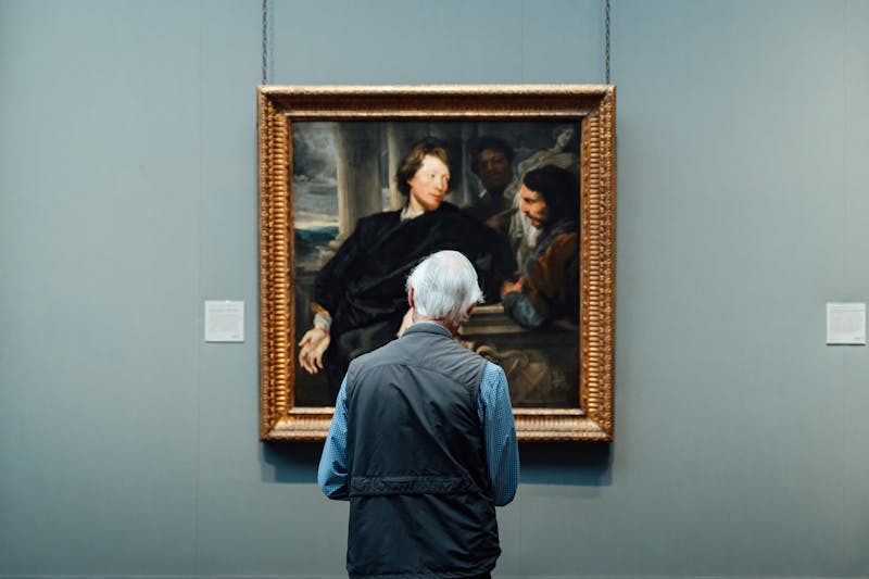 Visitor admiring classic painting in an art gallery