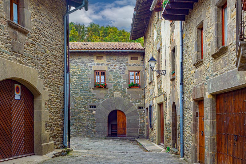 Narrow stone alleyway between old buildings in a medieval Catalan village
