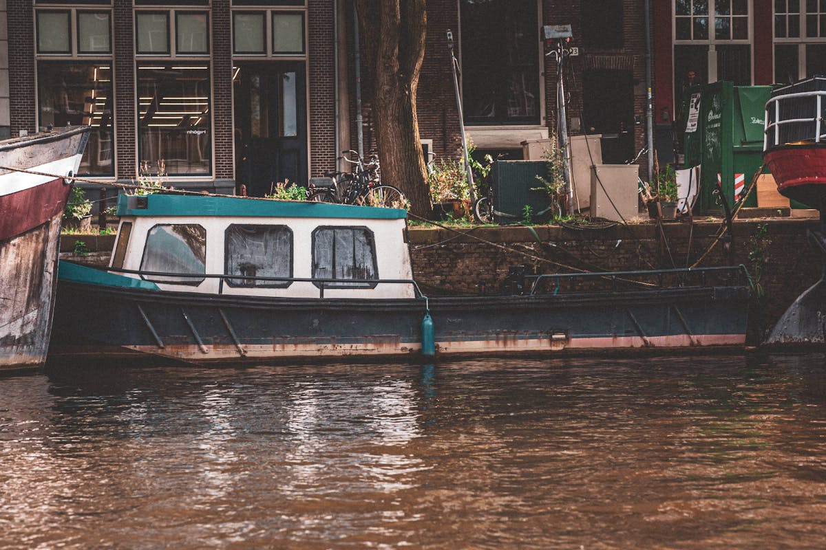 Traditional boat moored along Amsterdam canal with historic buildings