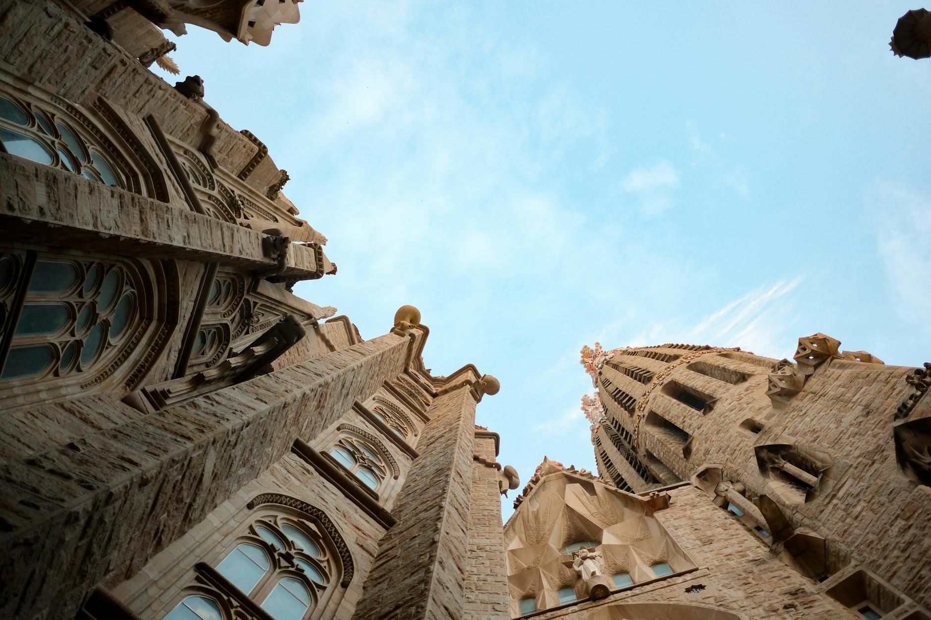 Upward view of Sagrada Familia towers against blue sky in Barcelona