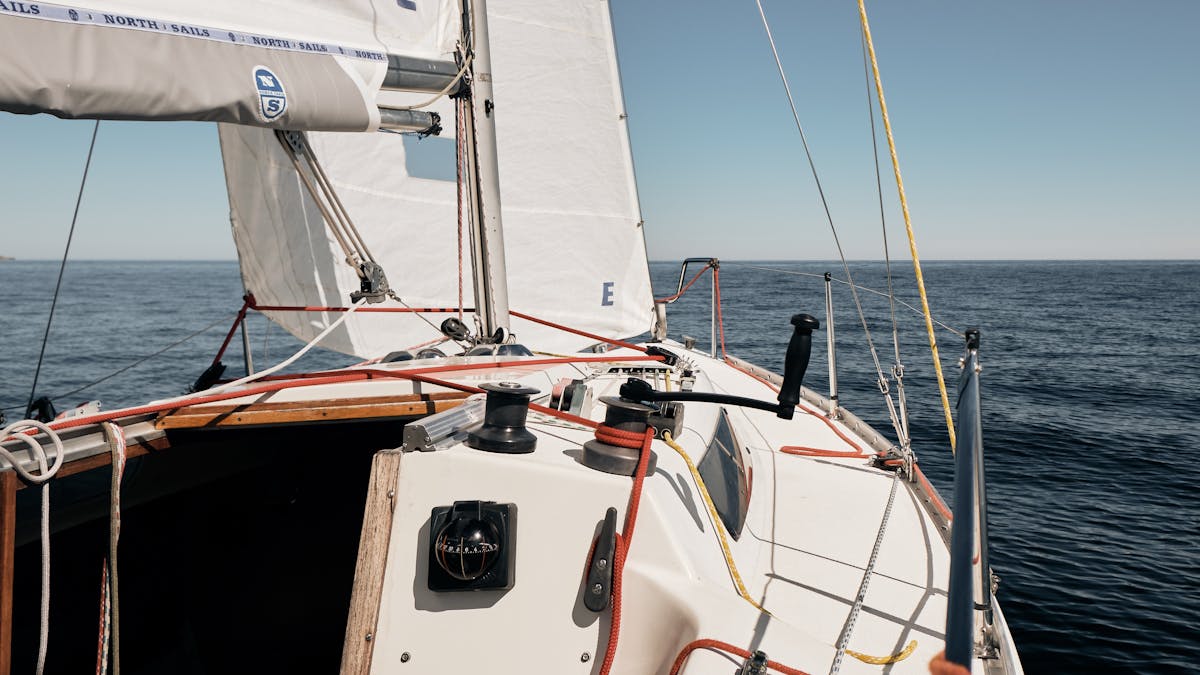 Sailboat navigating open sea under clear skies