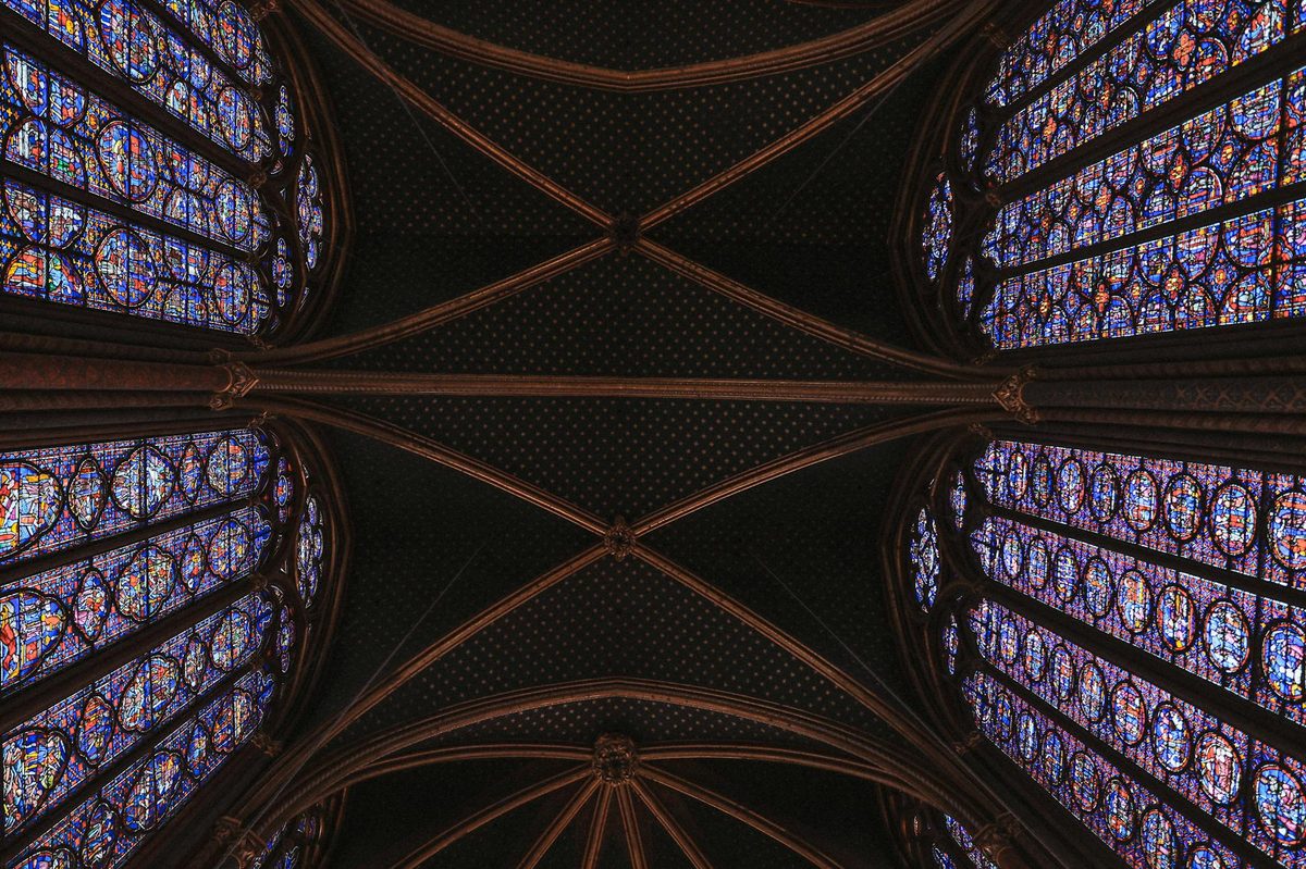 Ornate painted ceiling and stained glass windows in Sainte-Chapelle Paris