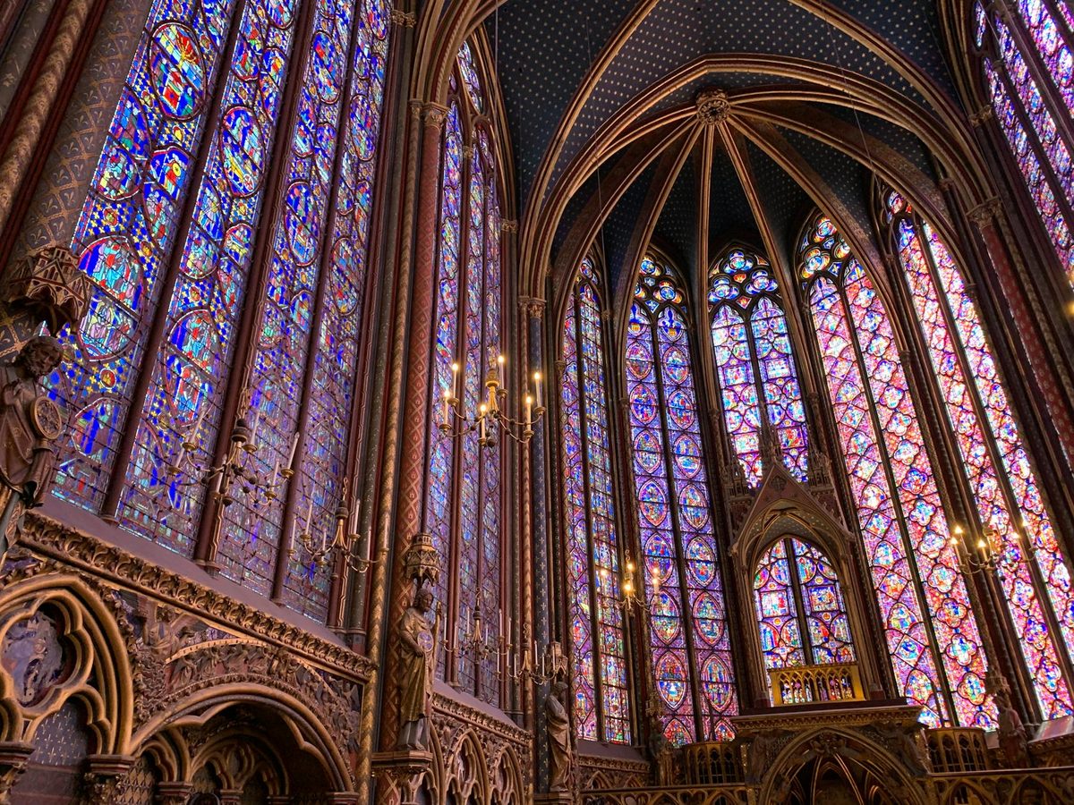 Tall stained glass windows in Sainte-Chapelle showing biblical scenes