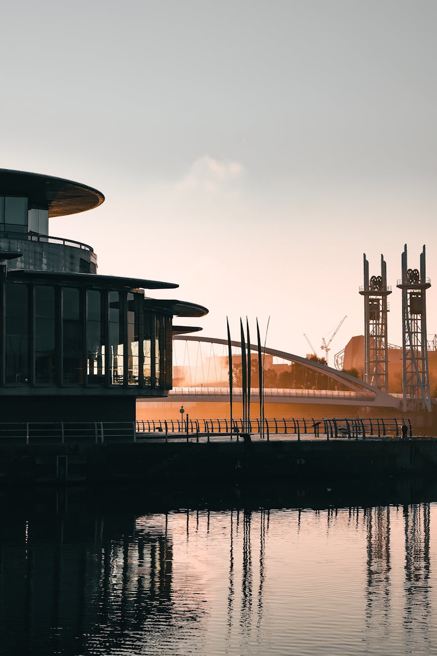 Golden sunset reflecting off the water at Salford Quays with modern buildings in silhouette