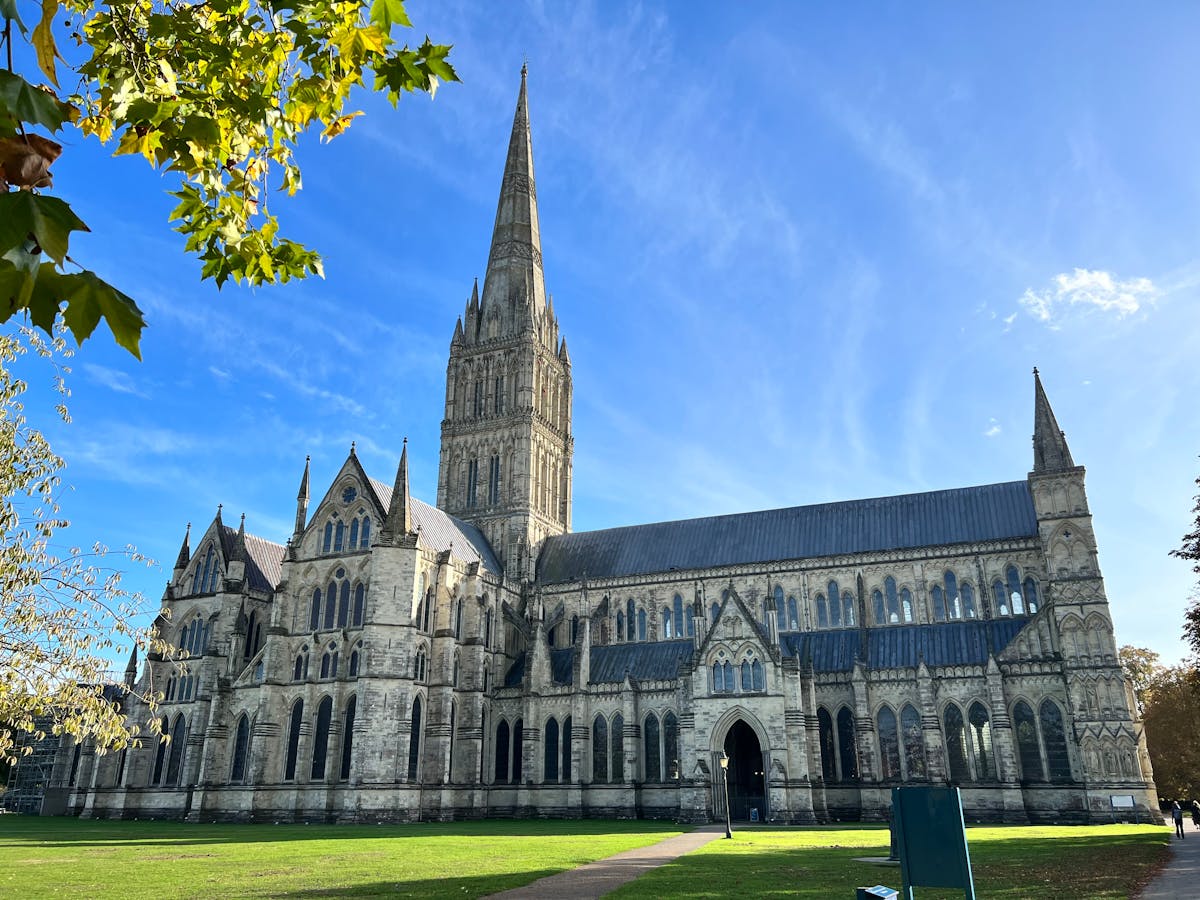 Salisbury Cathedral with tall spire under clear blue sky