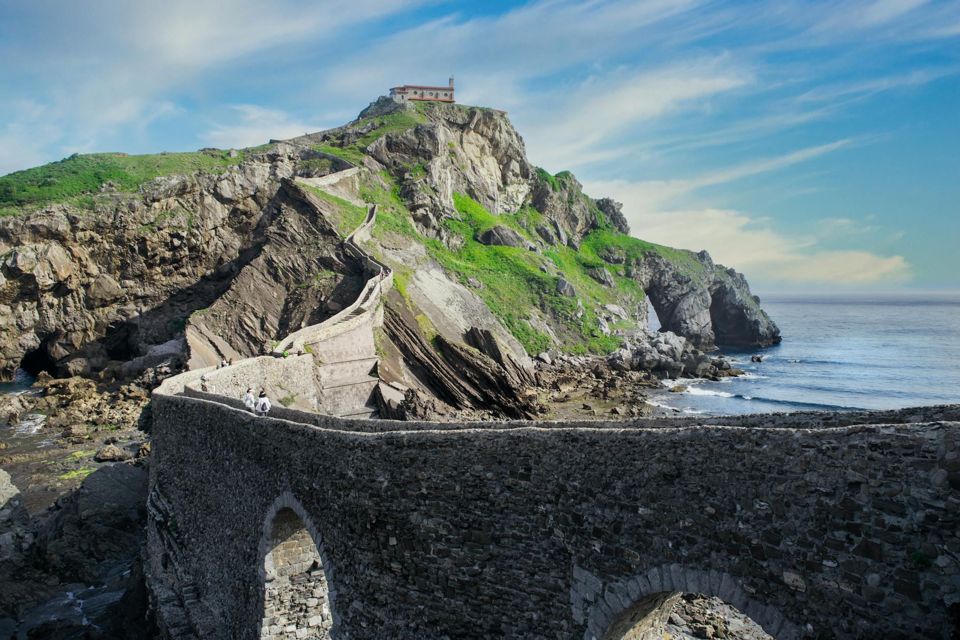 Scenic view of San Juan de Gaztelugatxe from the Basque Country coastline with green hills and ocean