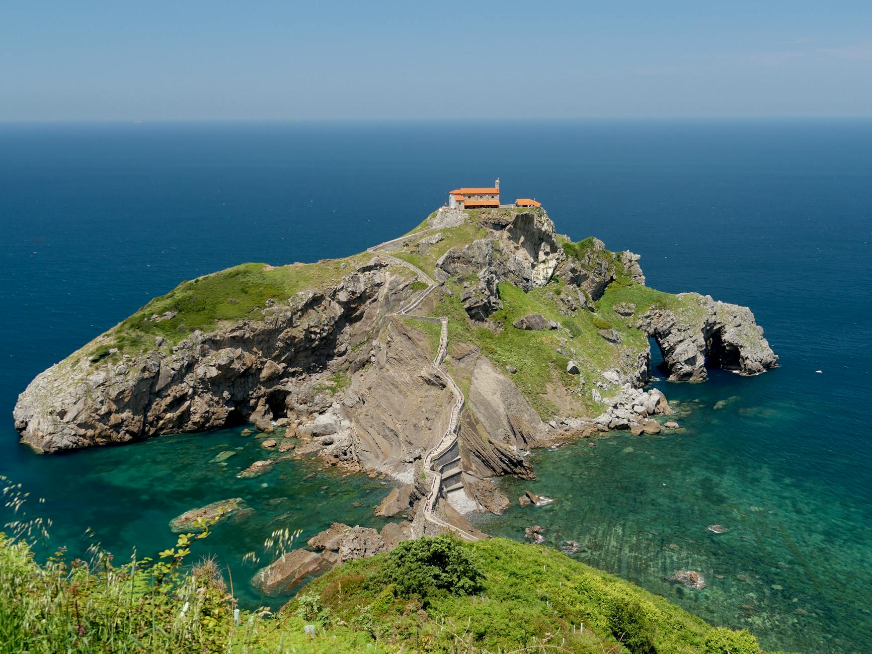 San Juan de Gaztelugatxe hermitage perched on rocky island with winding path and staircase visible