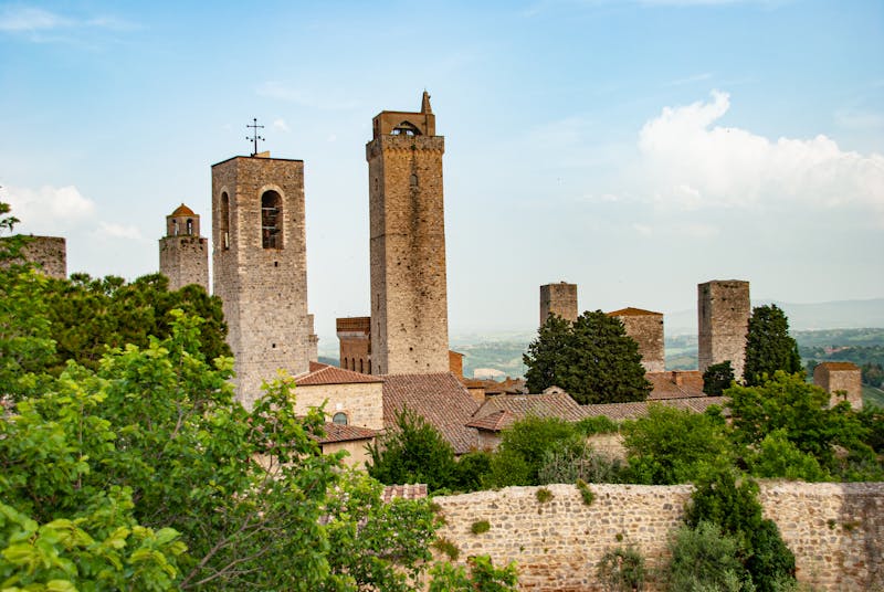 Tall medieval stone towers rising above the rooftops of San Gimignano Italy