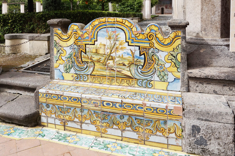 The cloister of the Basilica of Santa Chiara in Naples showing colorful majolica tile columns and garden walkways