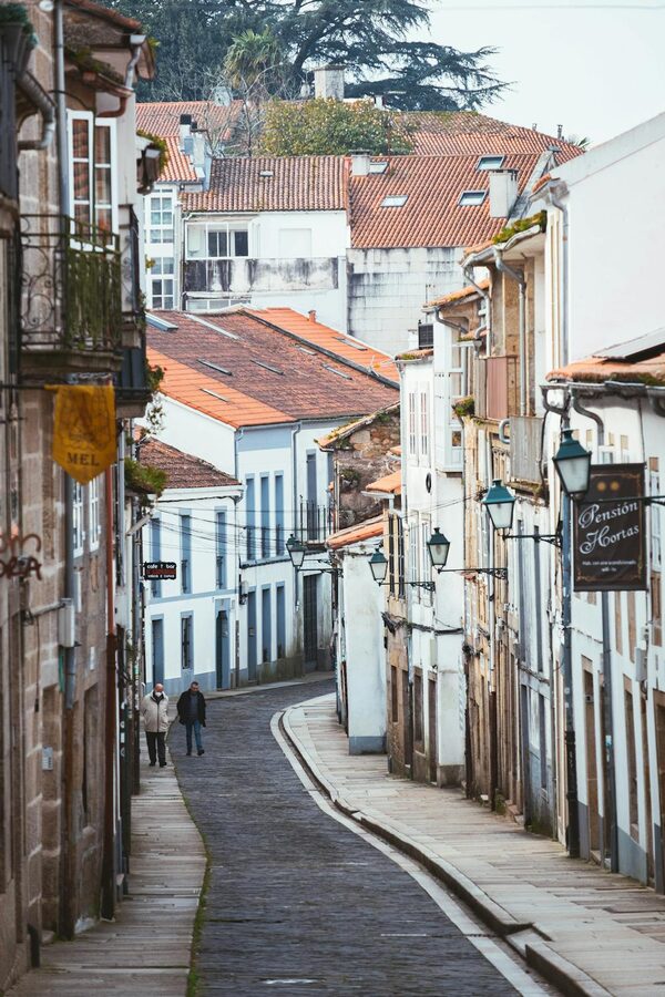 People walking along a cobblestone street in Santiago de Compostela old town