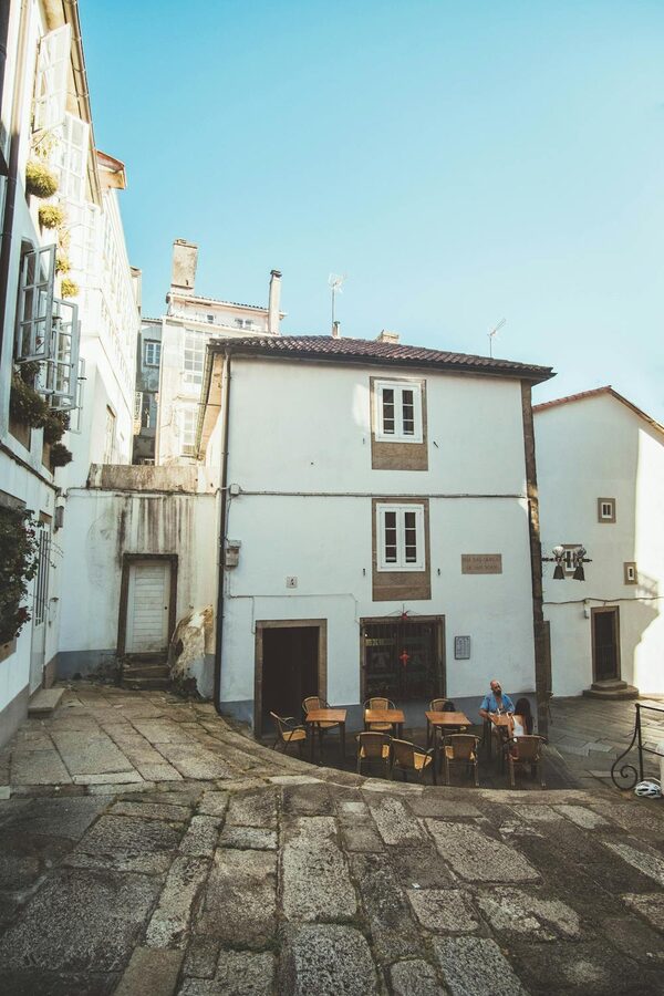 Tables set at an outdoor cafe in the old town of Santiago de Compostela