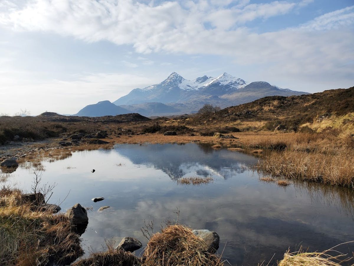 A peaceful Scottish loch reflecting snow-capped mountains
