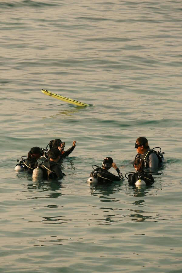 Scuba divers practicing skills in open water on a sunny day