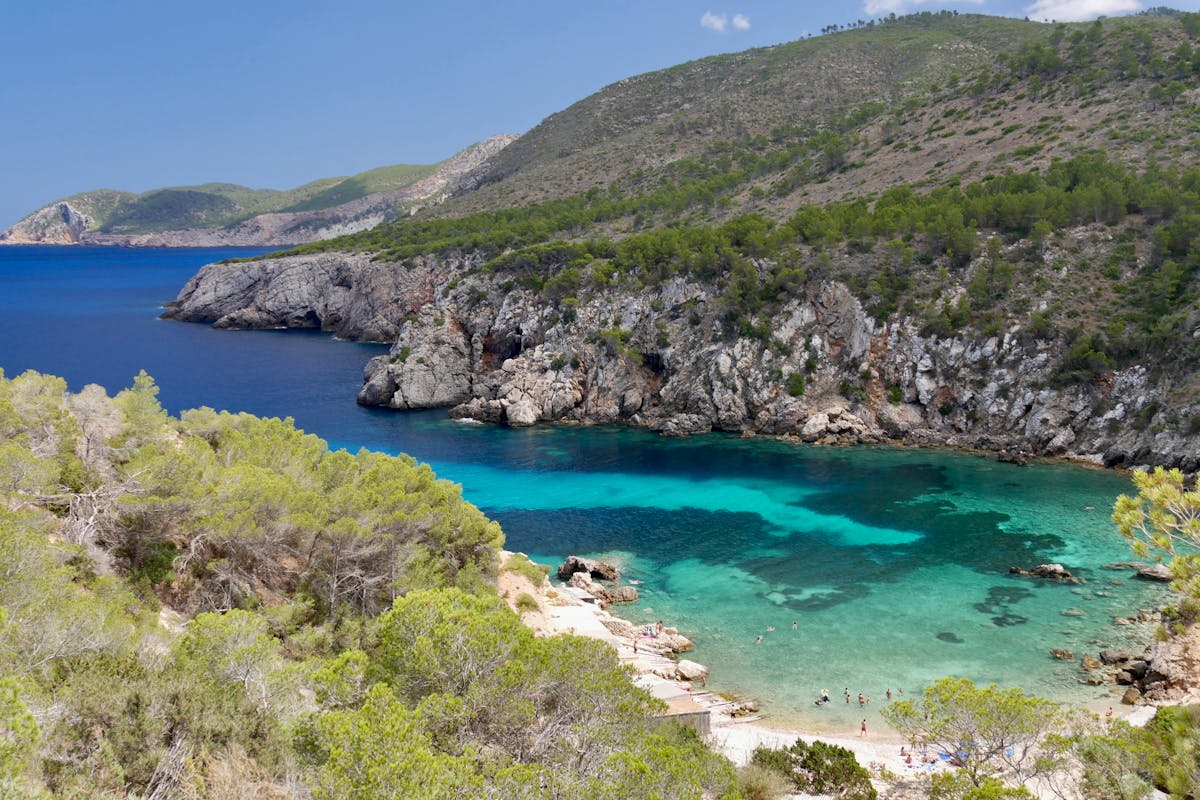 Hidden rocky cove along the Ibiza coast with pristine turquoise water