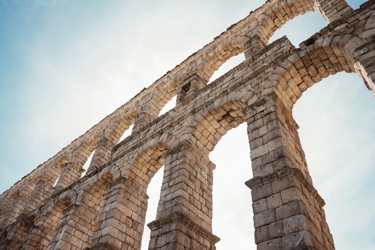 Low angle view of Segovia Roman aqueduct stone arches under a clear sky