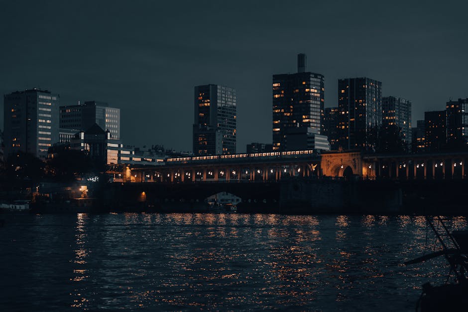 The Paris city skyline with illuminated buildings reflected on the river at night