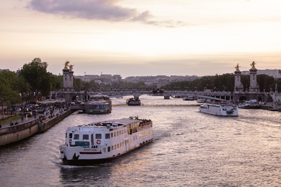 Golden sunset over the Pont Alexandre III bridge with cruise boats on the Seine River in Paris
