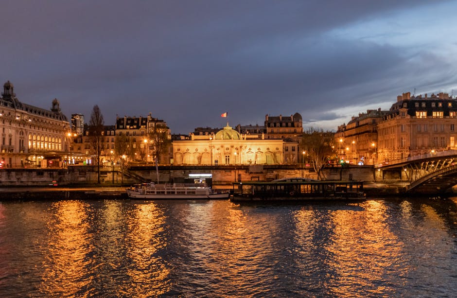 Illuminated Parisian landmarks and historic bridges reflected in the Seine River waters at night
