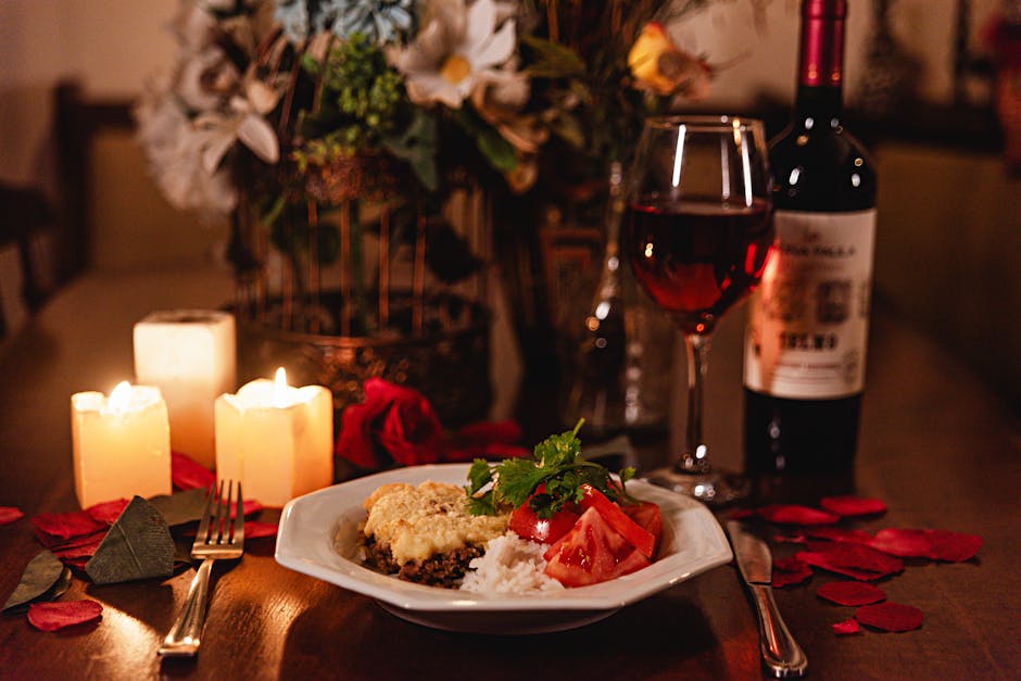 A cozy candlelit dinner table set with wine glasses and romantic decor