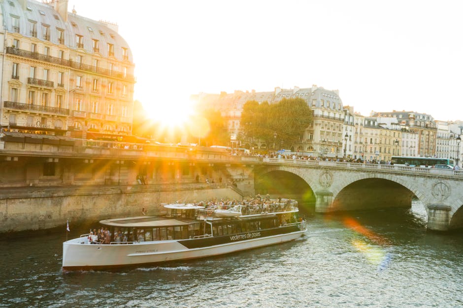 A cruise boat sailing along the Seine River in Paris at sunset with warm light on the buildings