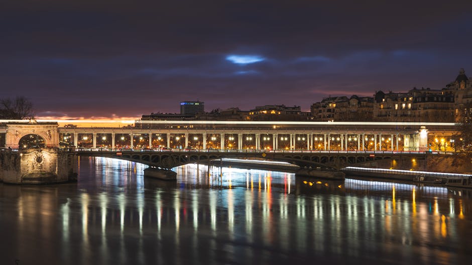 Pont de Passy bridge illuminated at night with reflections on the Seine River in Paris