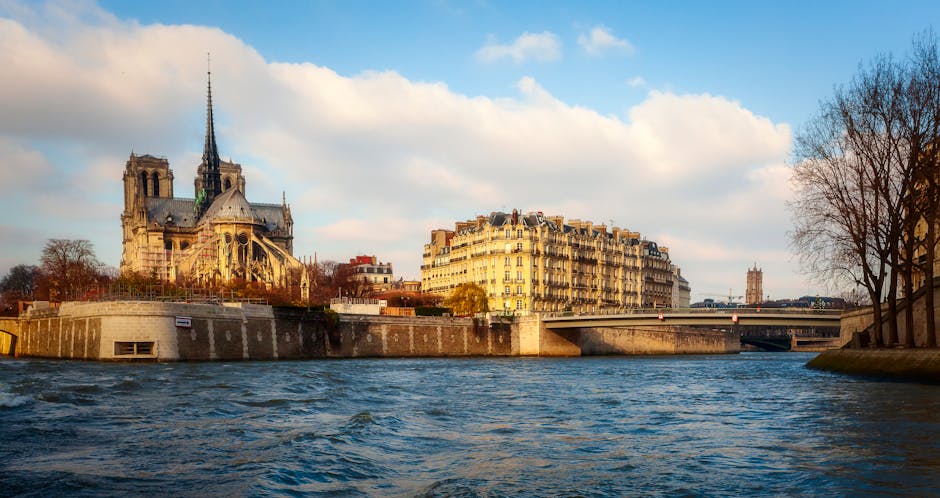 Notre Dame Cathedral alongside the Seine River on a clear day in Paris