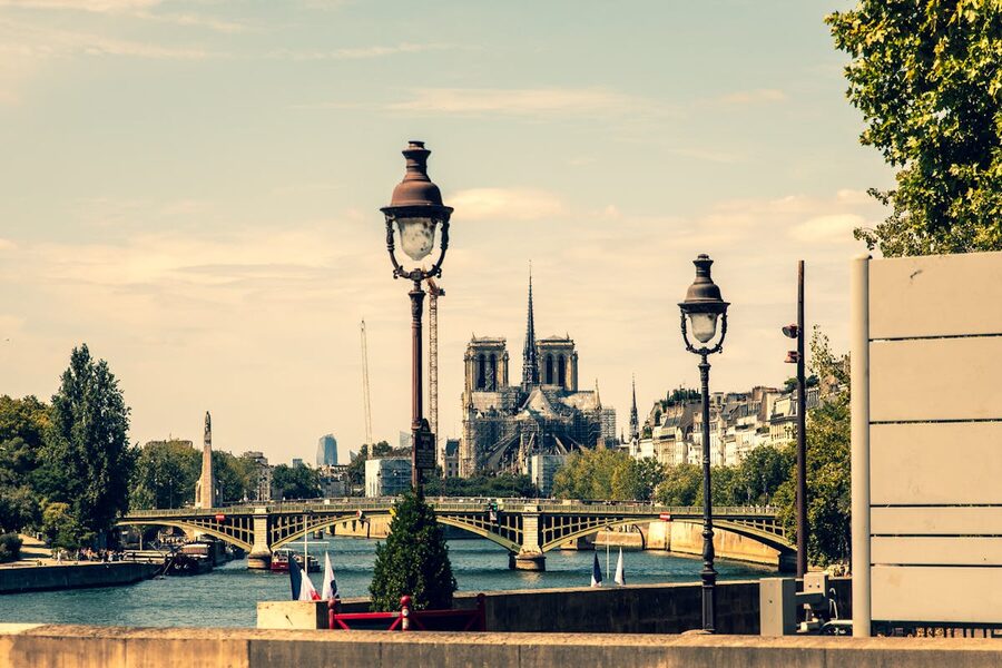 Notre Dame Cathedral and the Seine River from a Parisian street with vintage lampposts
