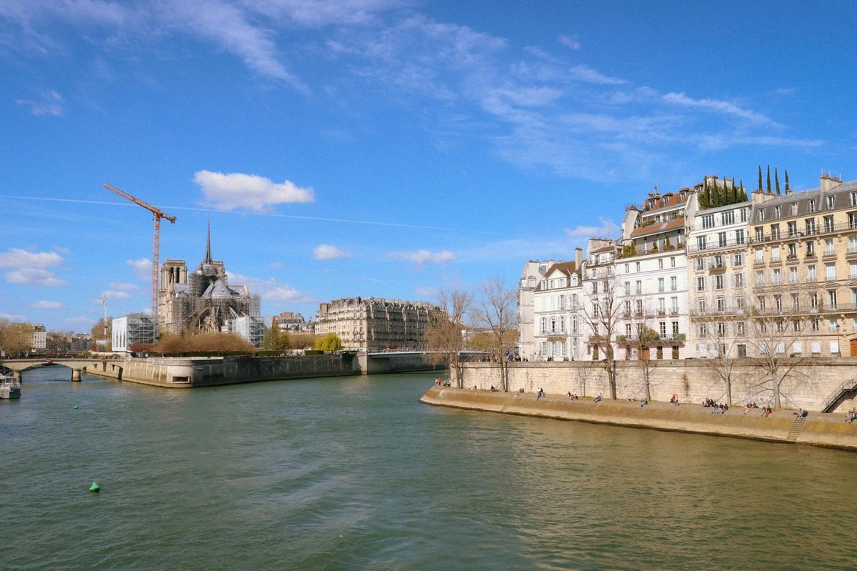 Bright view of the Seine River with Notre-Dame Cathedral and Parisian buildings