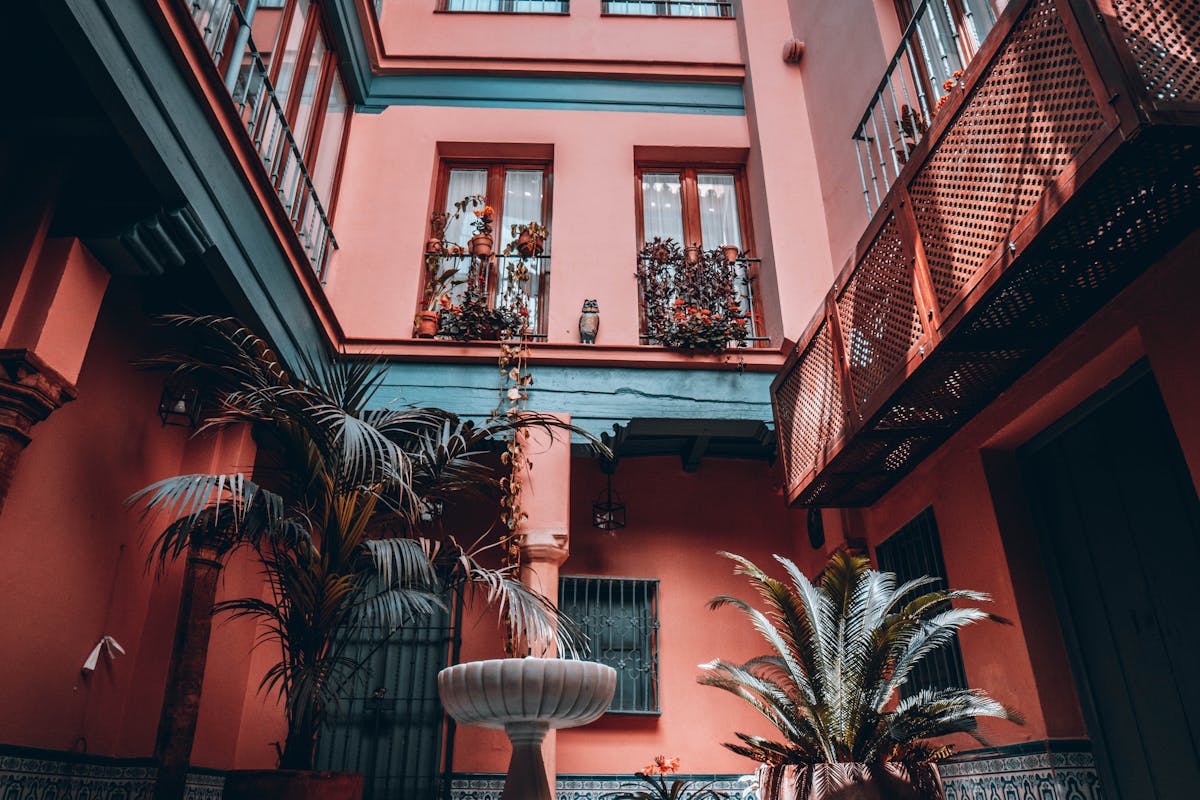 A courtyard with a central fountain and palm trees