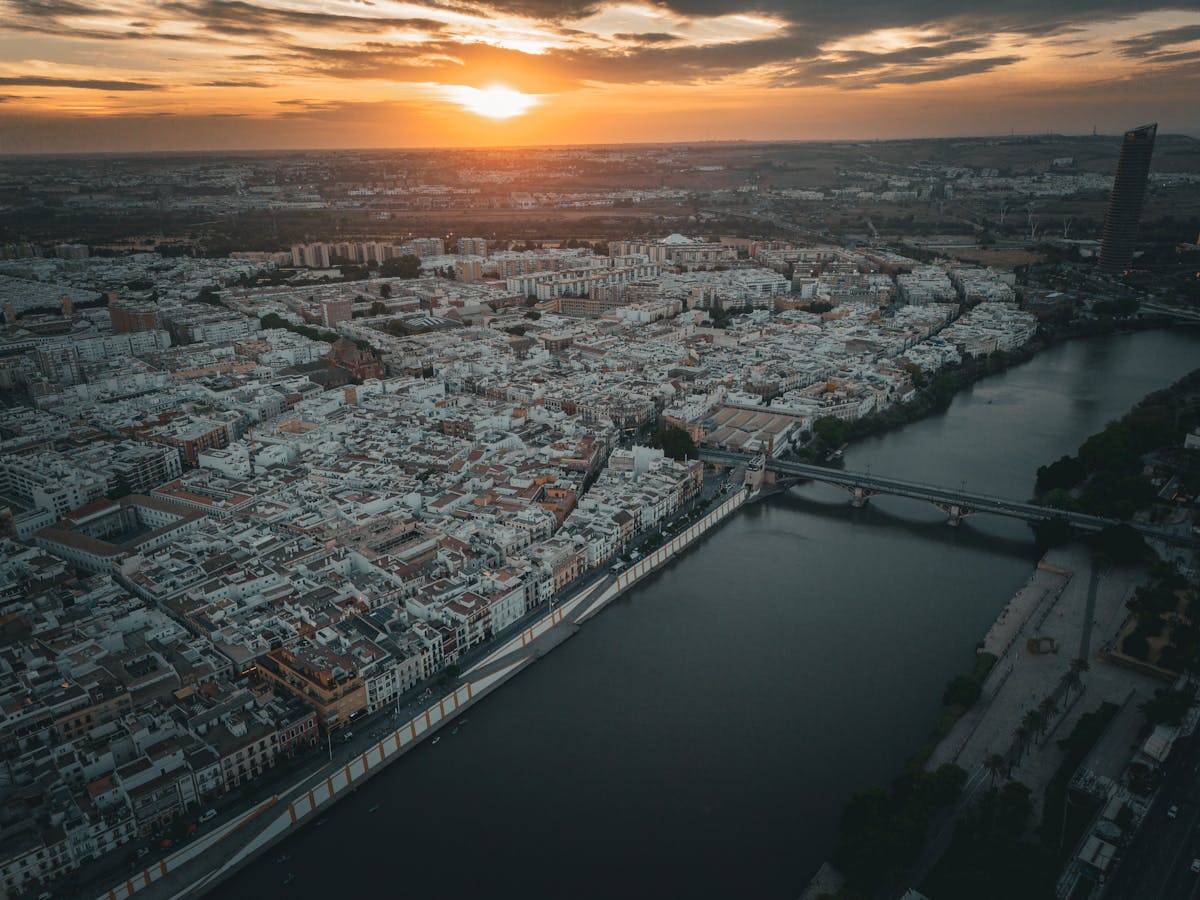 Aerial view of the Guadalquivir River winding through Seville at sunset